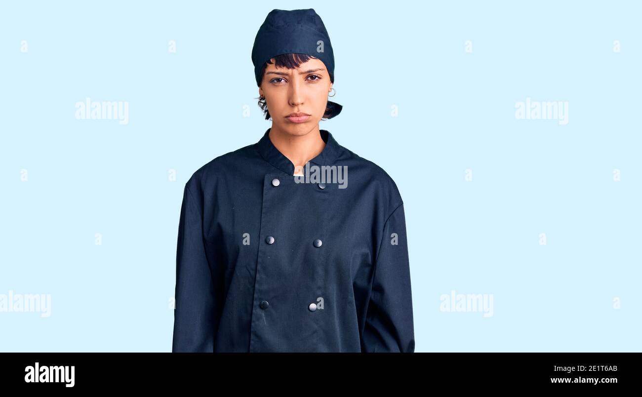 Young brunette woman with short hair wearing professional cook uniform ...