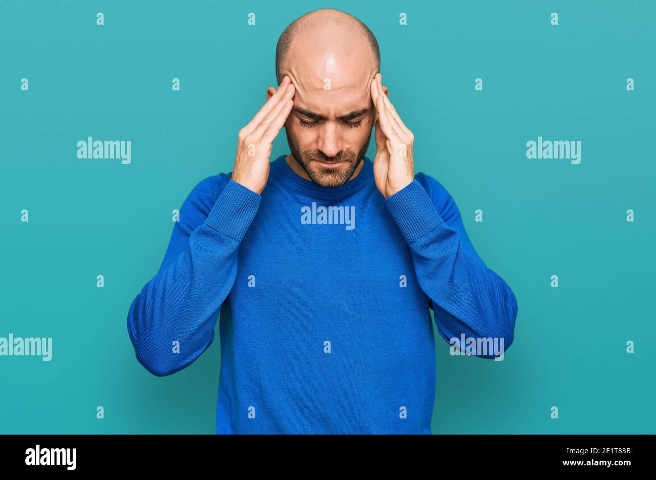 Young hispanic man wearing casual clothes with hand on head for pain in ...