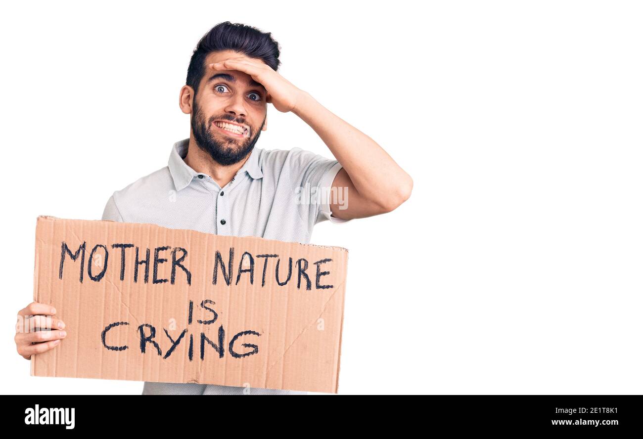Young handsome man with beard holding mother nature is crying cardboard ...
