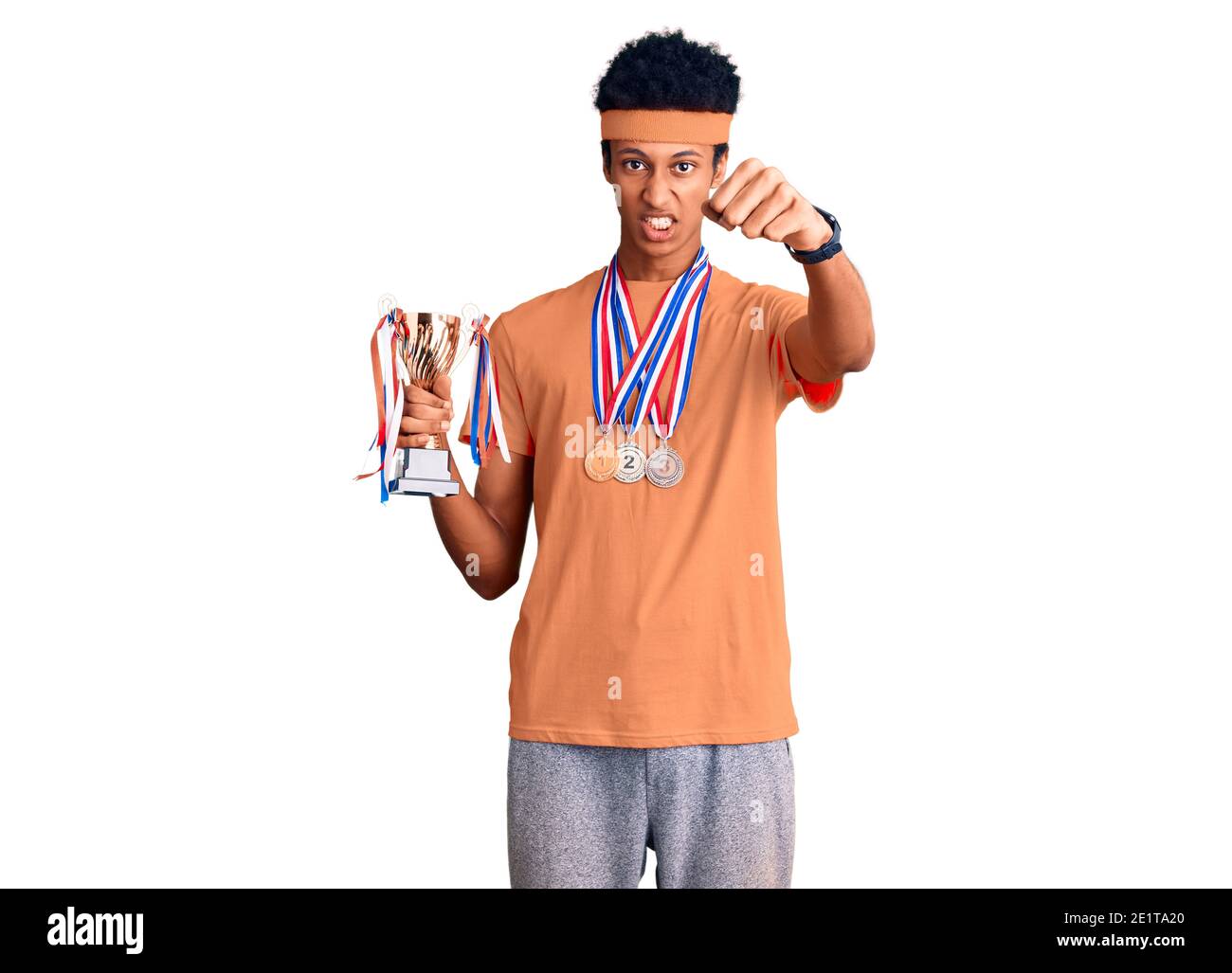 Young african american man holding champion trophy wearing medals ...