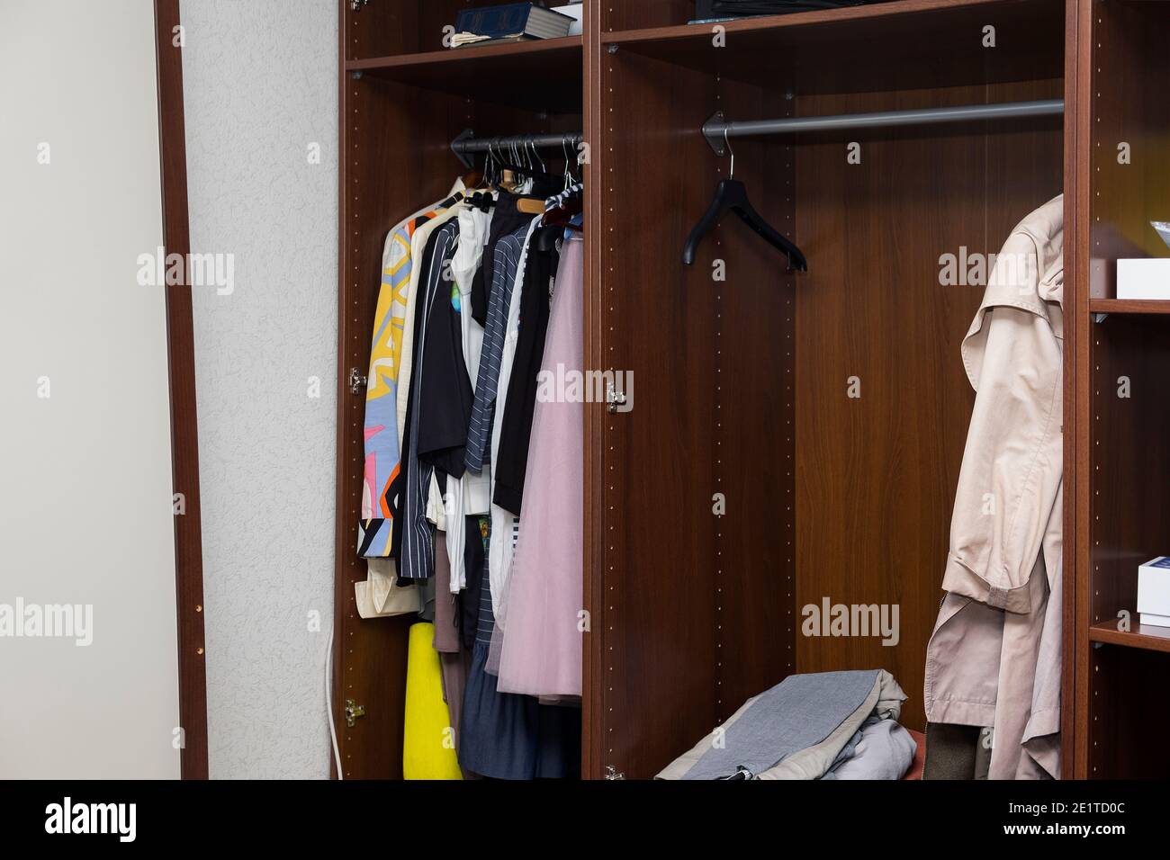 A wardrobe with removed doors and colthing inside, indoor shot Stock ...