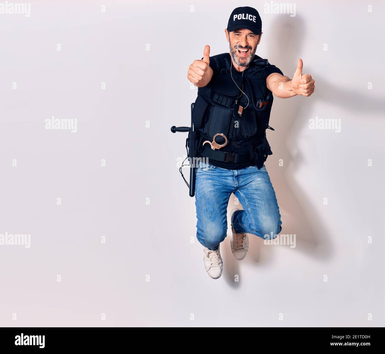 Middle age handsome man wearing police unifrom smiling happy. Jumping ...