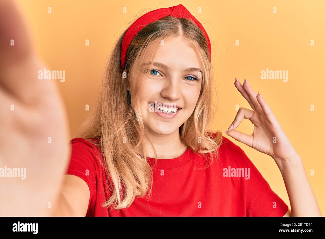 Beautiful young caucasian girl taking a selfie photo doing ok sign with ...
