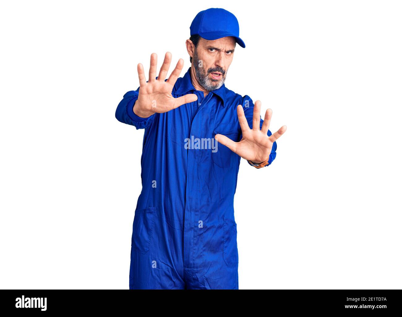 Middle age handsome man wearing mechanic uniform doing stop gesture ...