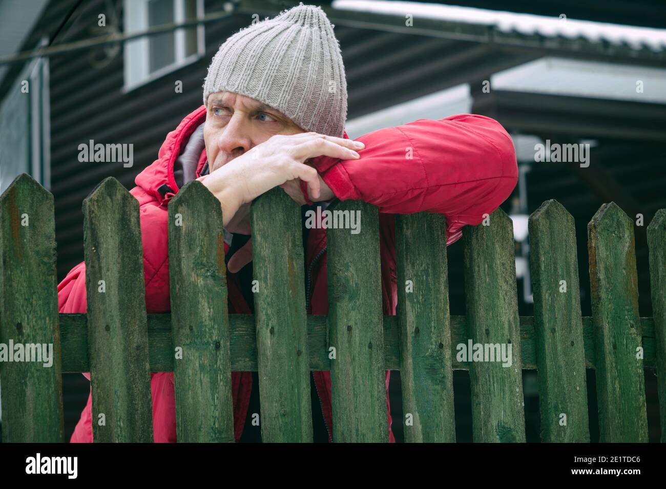 A man with suspicious face looking out into the street, concept of ...
