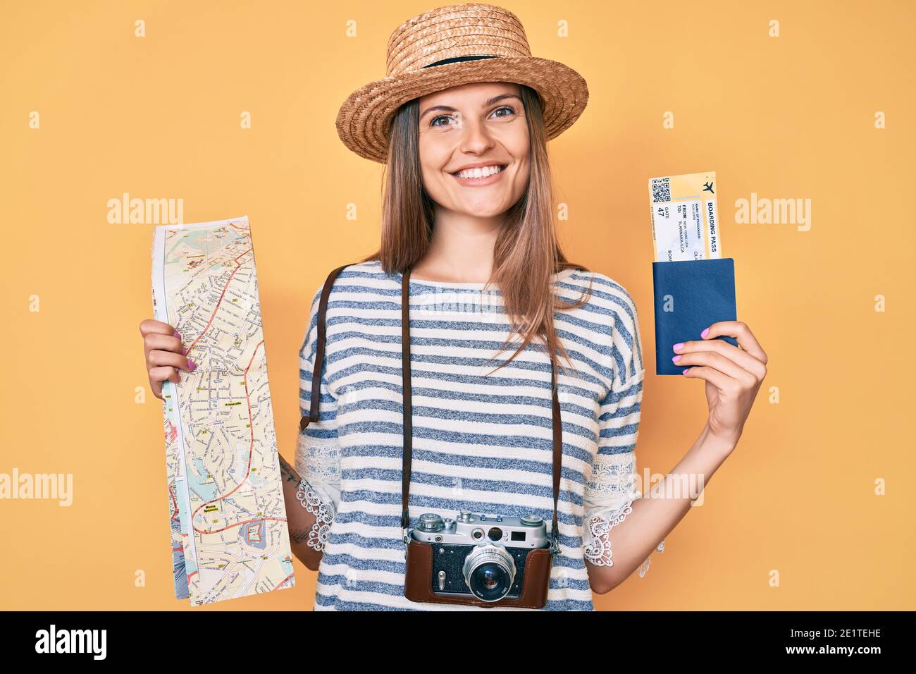 Beautiful caucasian tourist woman holding city map and passport smiling ...