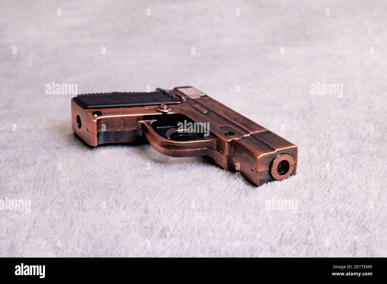 Metal fake pistol on gray background close up Stock Photo - Alamy