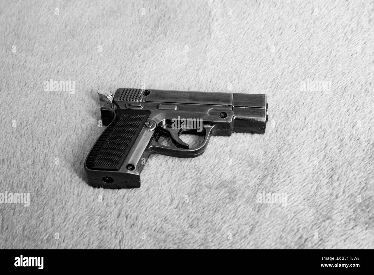 Metal fake pistol on gray background close up, black and white Stock ...