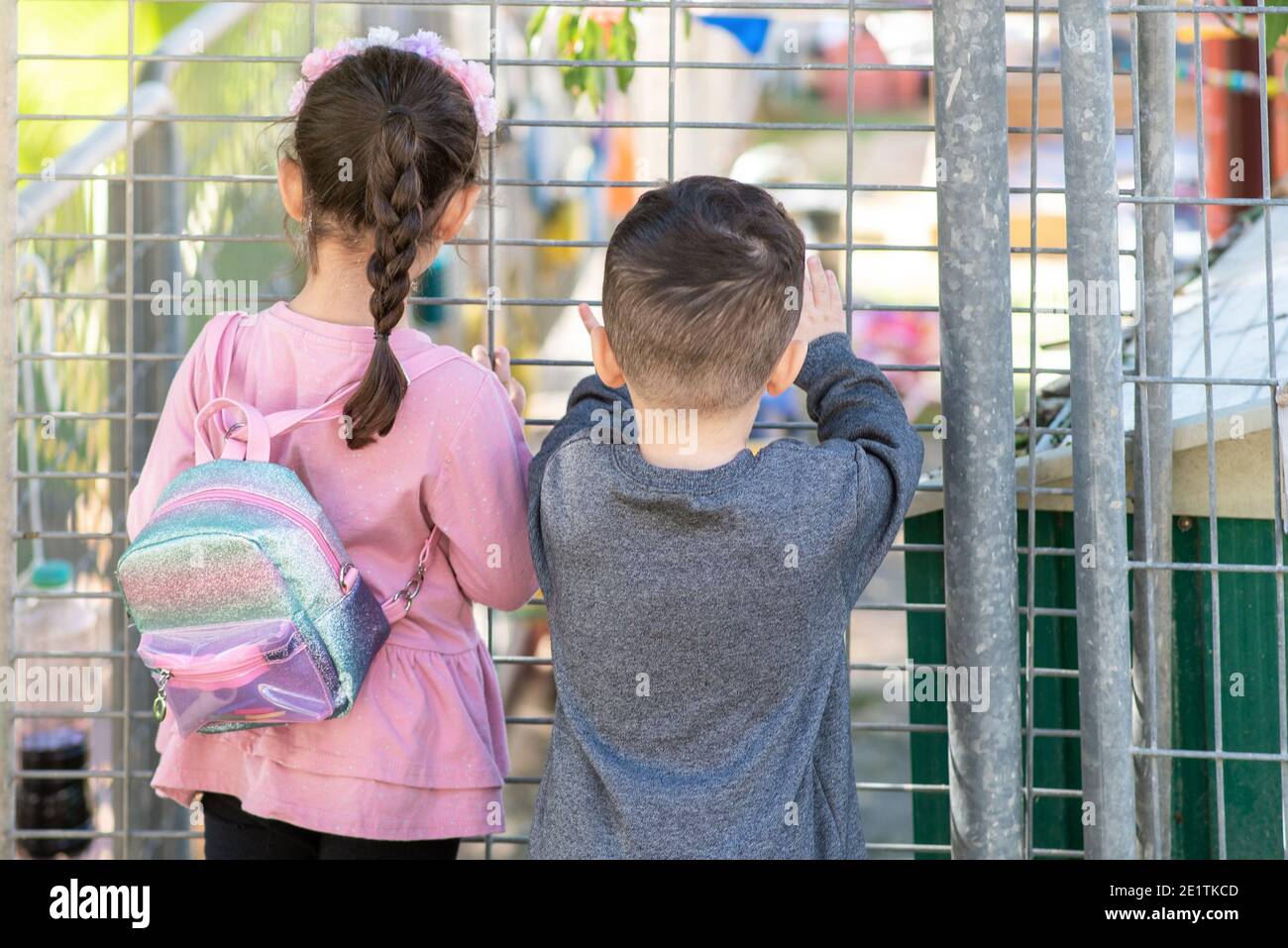 Children near the gate of closed preschool. Little kids outside school ...