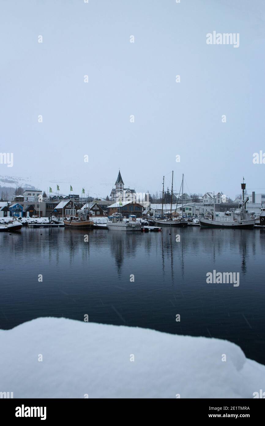 Winter wonderland snow landscape boat ship in harbour port of Husavik ...