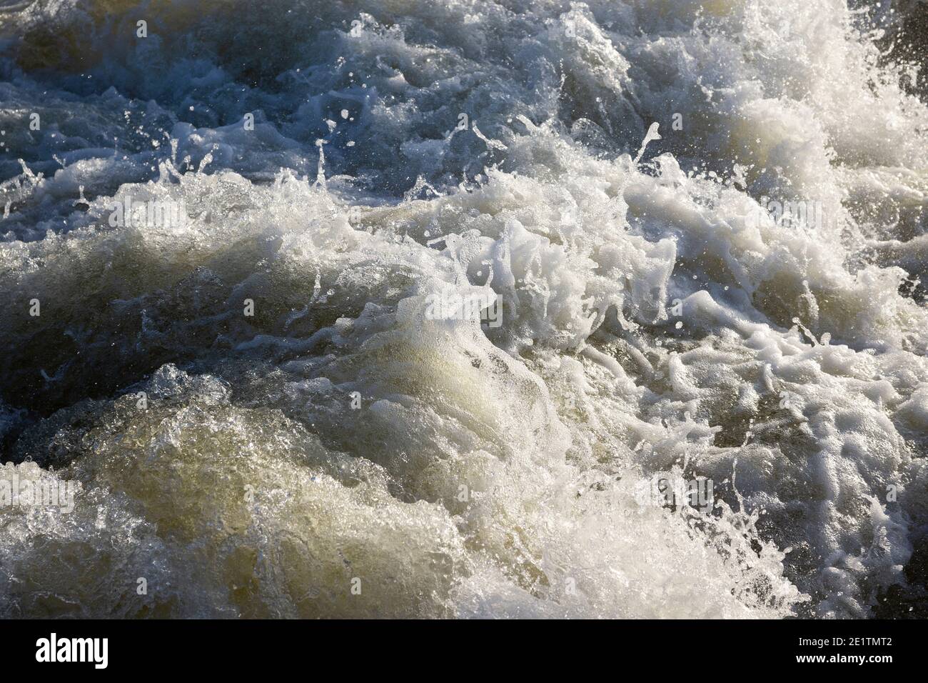 Foaming white water flowing over a river weir Stock Photo - Alamy