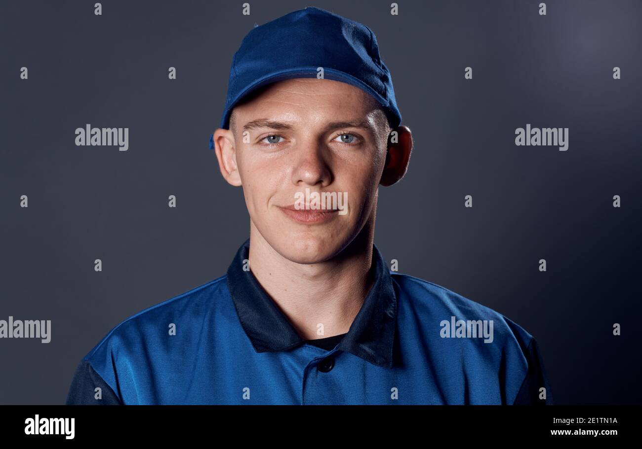Man in a working uniform blue cap work delivery service Stock Photo - Alamy