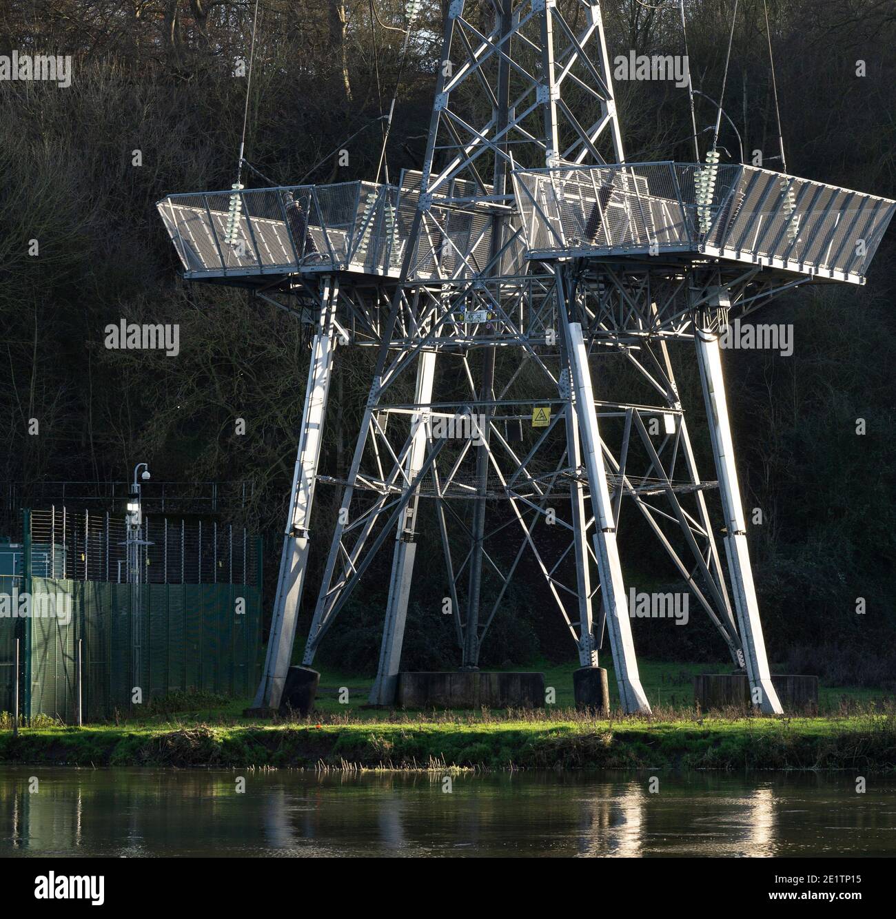 electricity cable pylon next to s river Stock Photo - Alamy