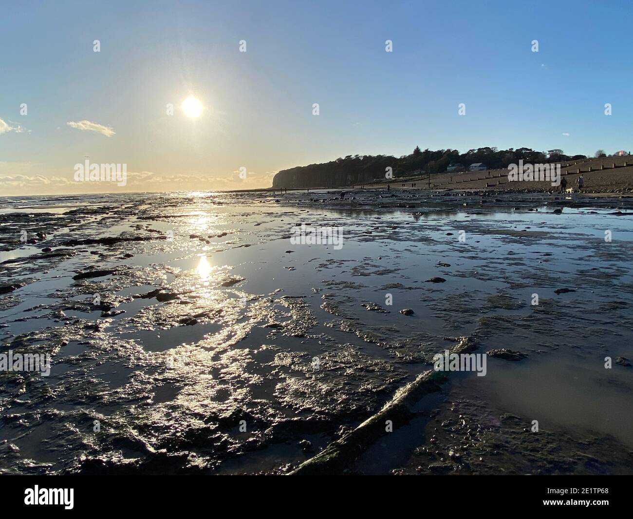 Pett Level Beach at Sunset. With pool of sea ocean water and rocks in ...