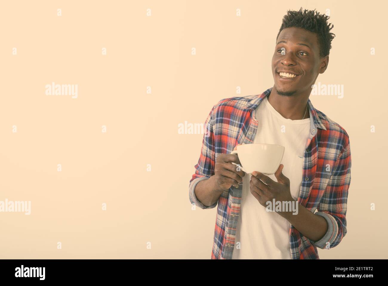 Studio shot of young happy black African man smiling while thinking and ...