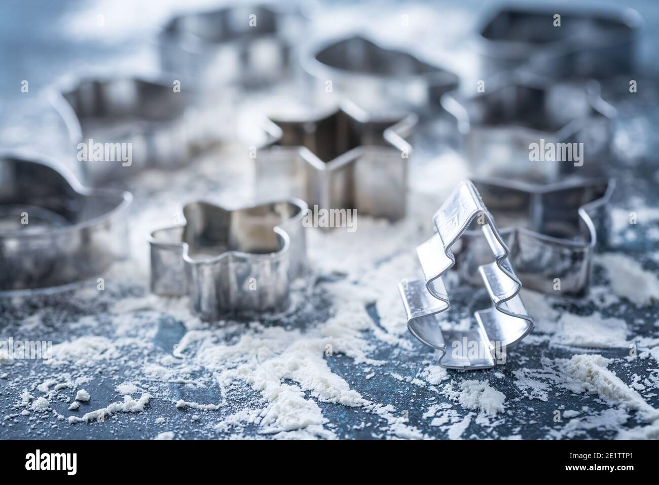 Christmas baking - cookie cutters and flour on dark background ...