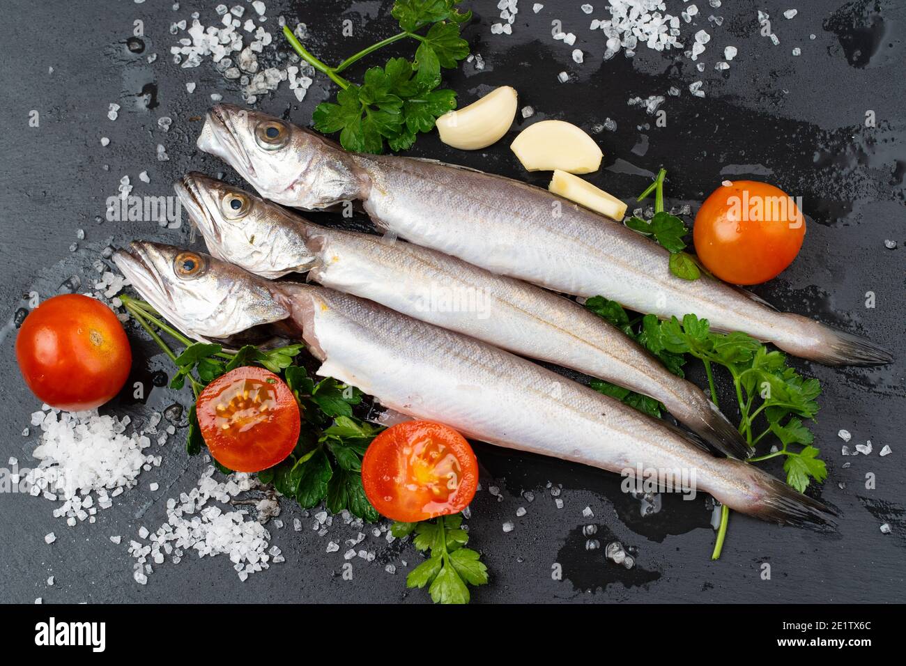 fresh cod on black stone board background with typical ingredients of ...