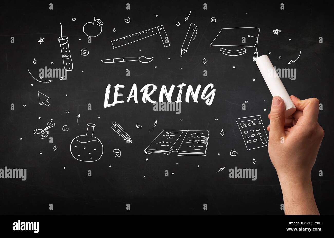 Hand drawing LEARNING inscription with white chalk on blackboard ...