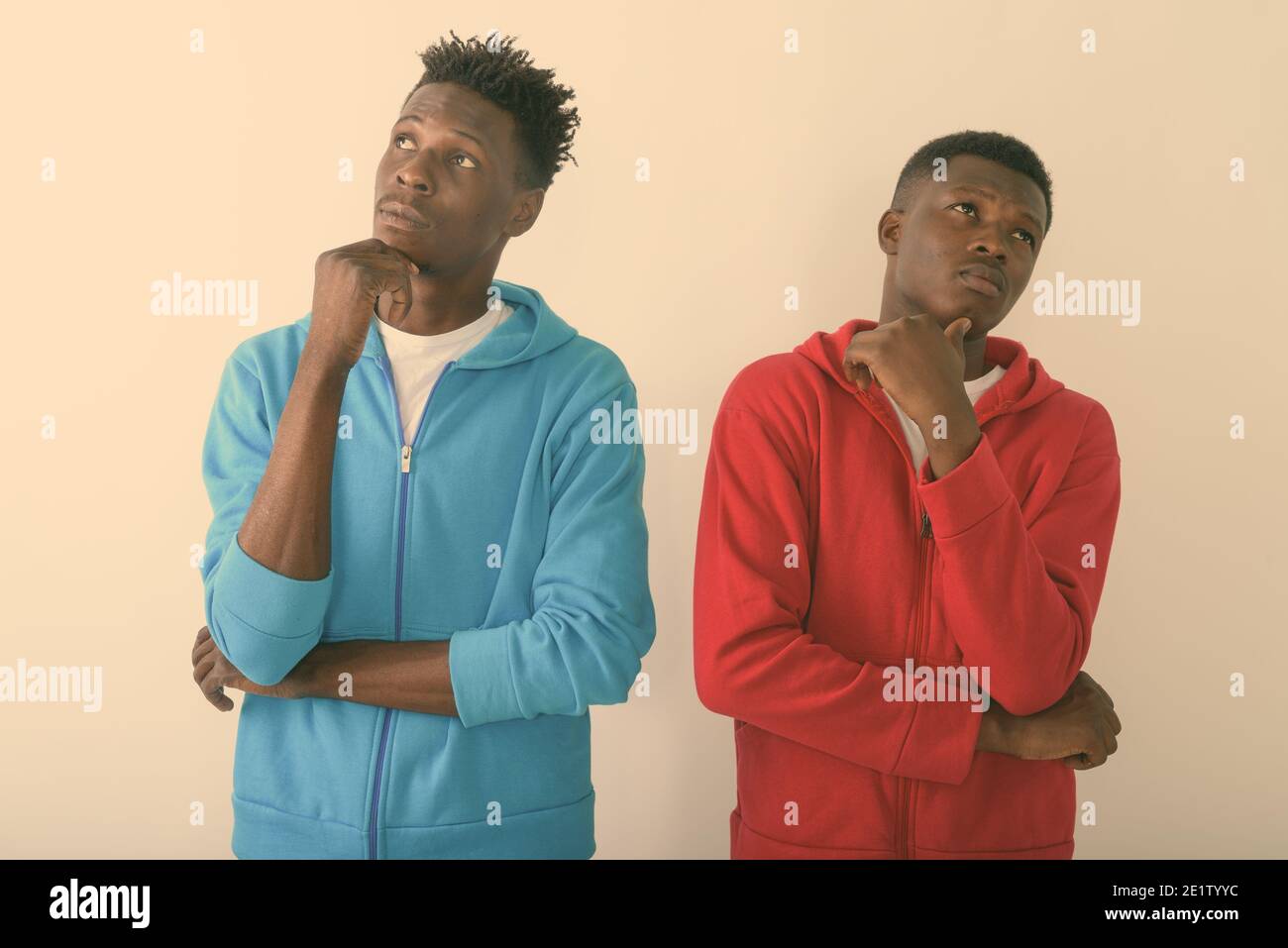 Studio shot of two young black African friends thinking while looking ...