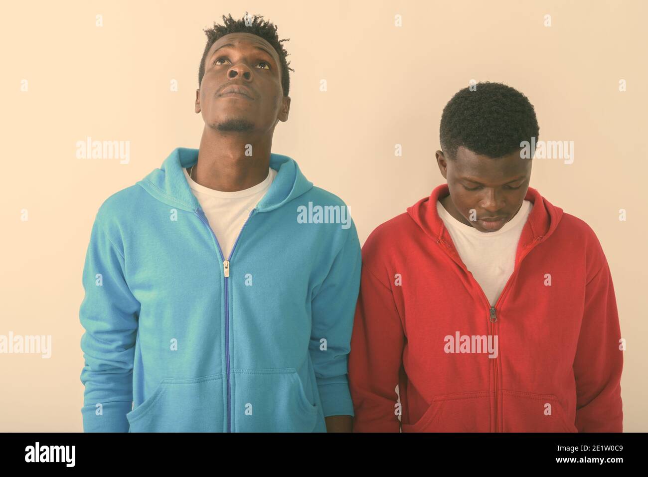 Studio shot of young slim black African man looking up with young black ...
