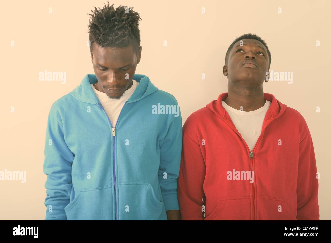 Studio shot of young black African man looking up with young slim black ...