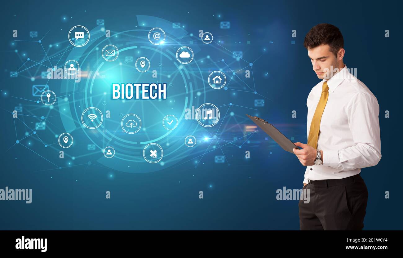 Businessman thinking in front of technology related icons and BIOTECH ...