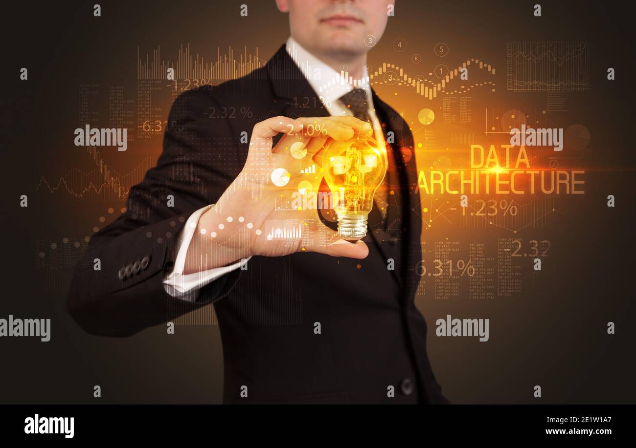 Businessman holding lightbulb with DATA ARCHITECTURE inscription ...