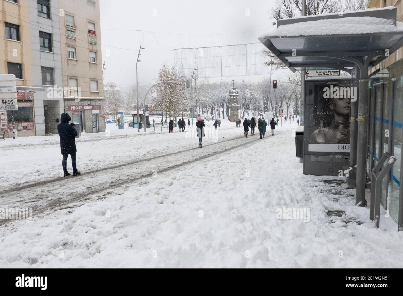 Empty bus stop with people walking on the road in Marques de Vadillo ...