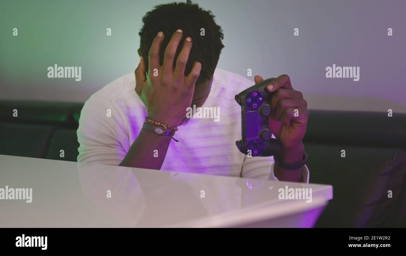 Sad black man lost game. Desperate man holding joystick controller ...