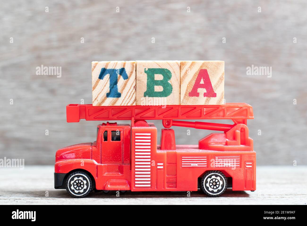 Red fire truck hold letter block in word TBA (abbreviation of to be ...