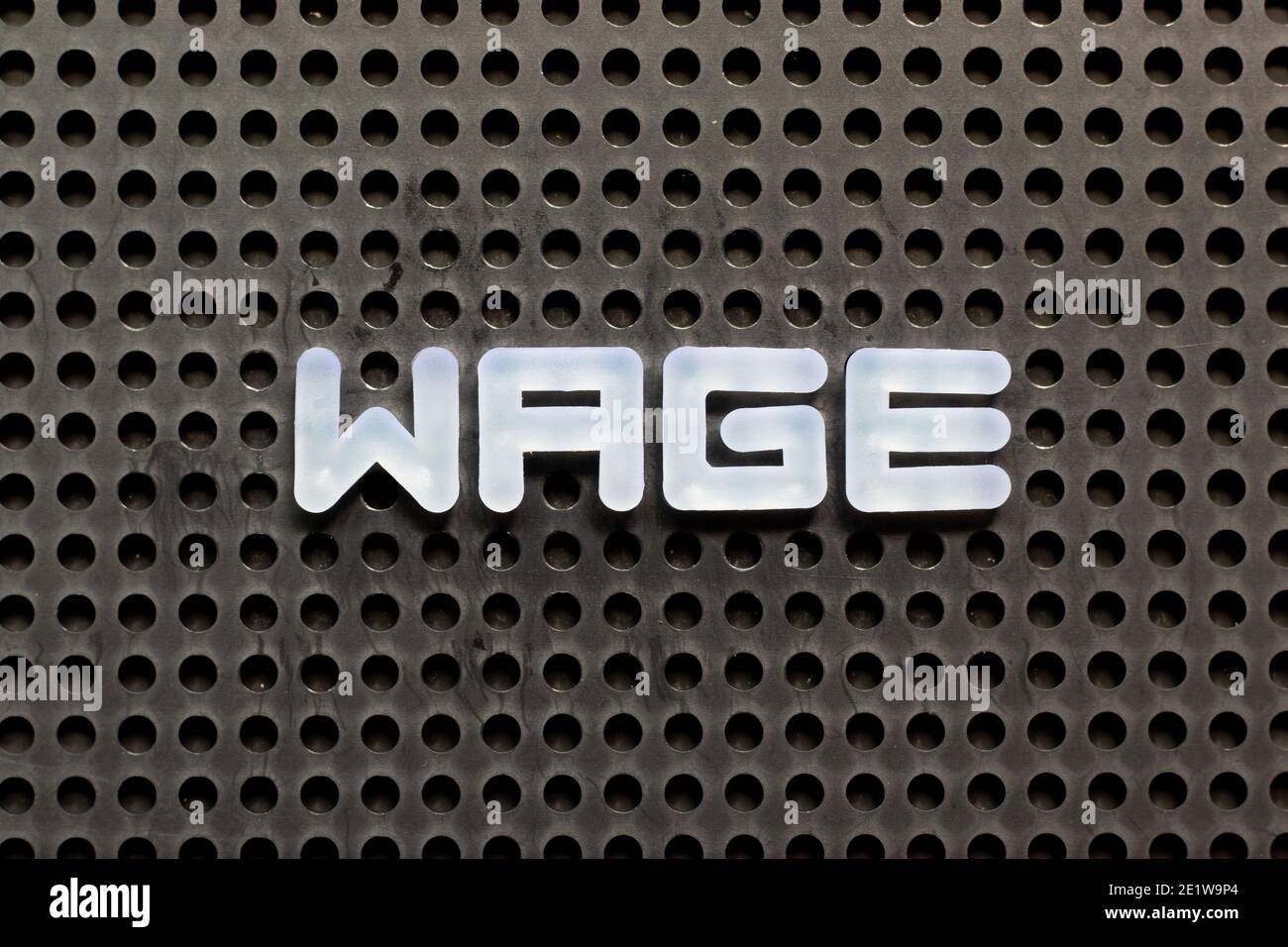 White color letter in word wage on black pegboard background Stock ...