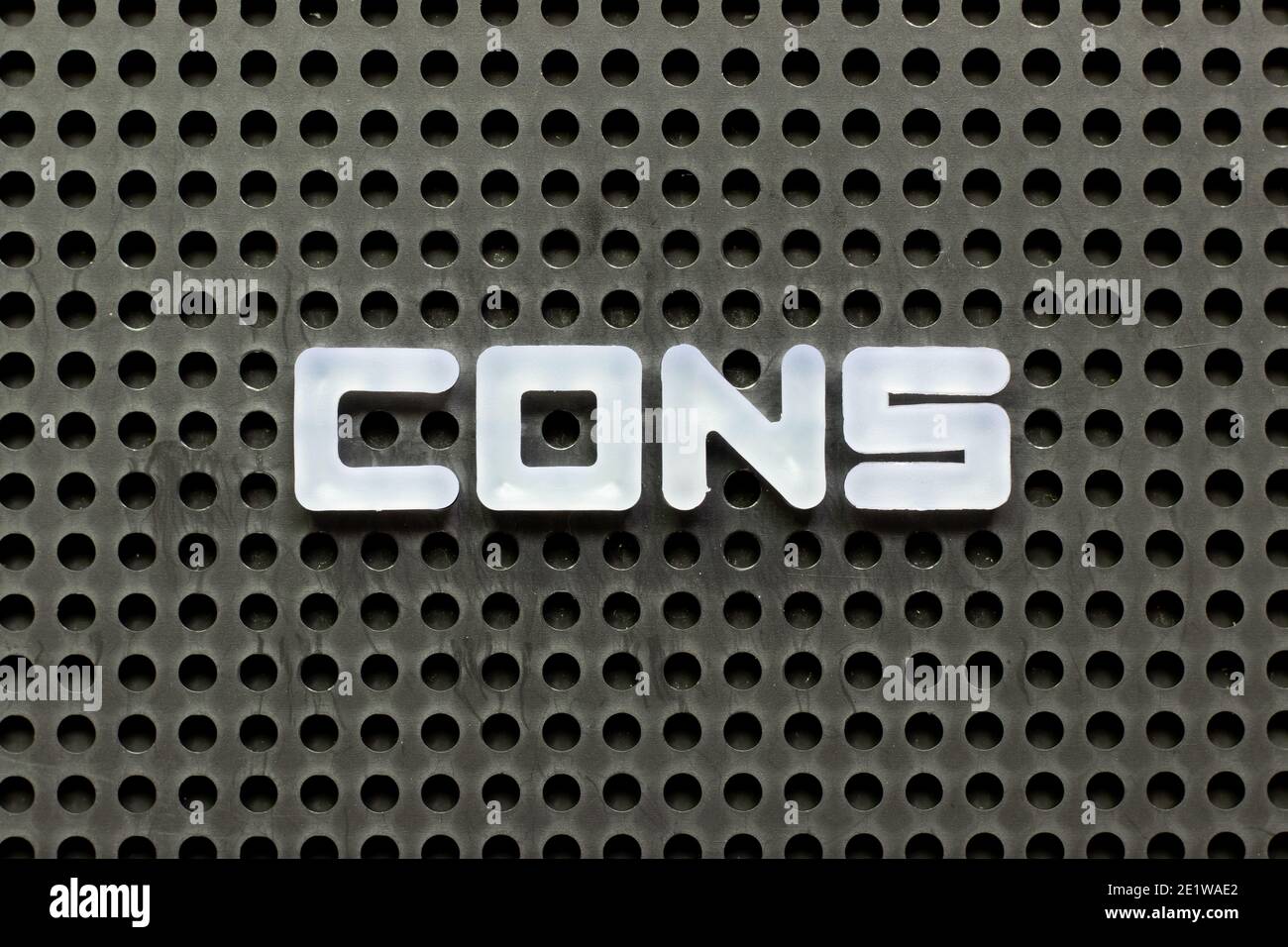 White color letter in word cons on black pegboard background Stock ...