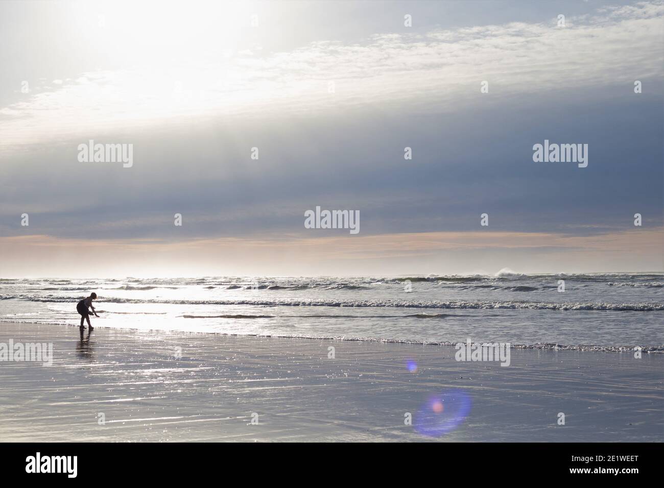 Silhouette of a person tossing something into the ocean Stock Photo - Alamy
