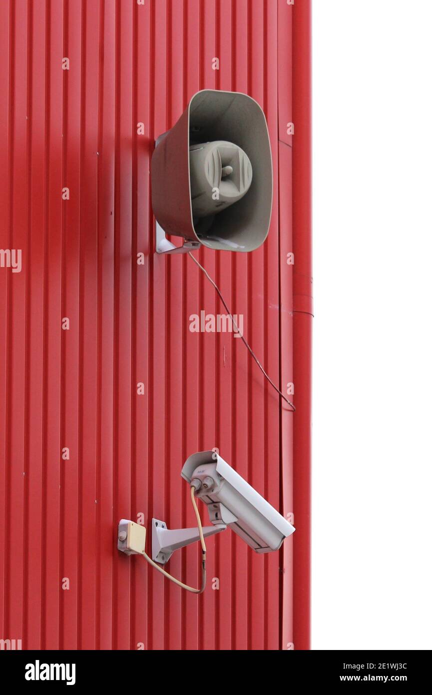 Surveillance camera mounted on red tiled wall of house. Security ...