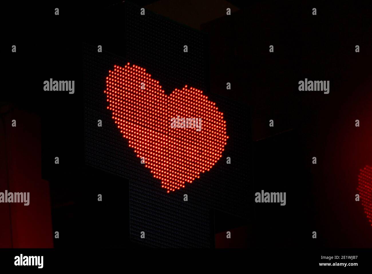 Glowing pixel red heart of LED lamps on black background. Red heart ...