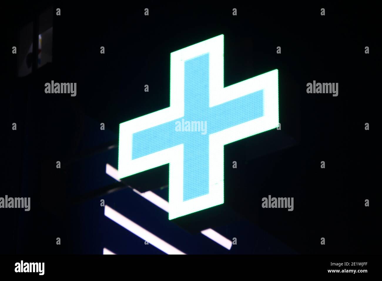 Glowing pixel cross of LED lamps on black background. White cross with ...