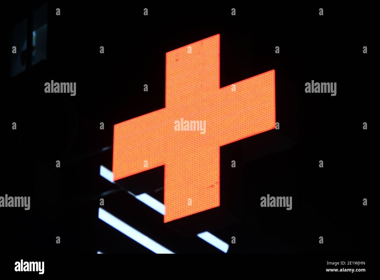 Glowing pixel cross of LED lamps on black background. Orange cross ...