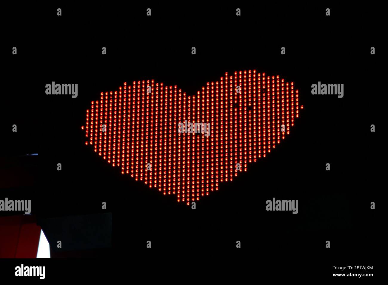 Glowing pixel red heart of LED lamps on black background. Red heart ...