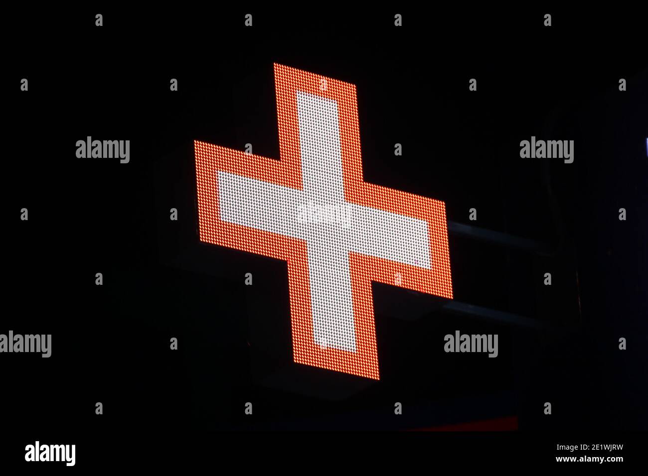 Glowing pixel cross of LED lamps on black background. Orange cross with ...