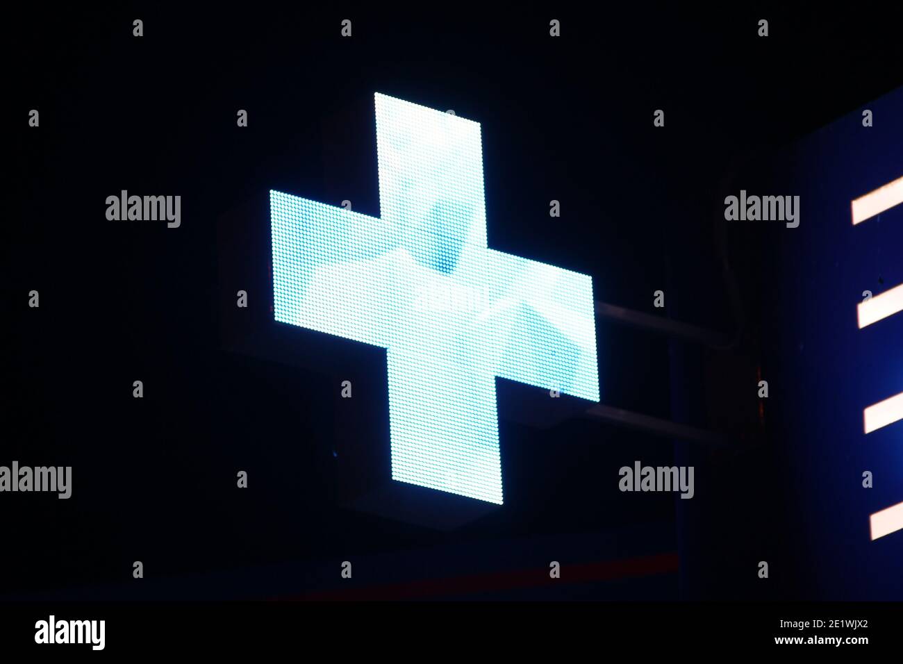Glowing pixel cross of LED lamps on black background. Blue cross symbol ...