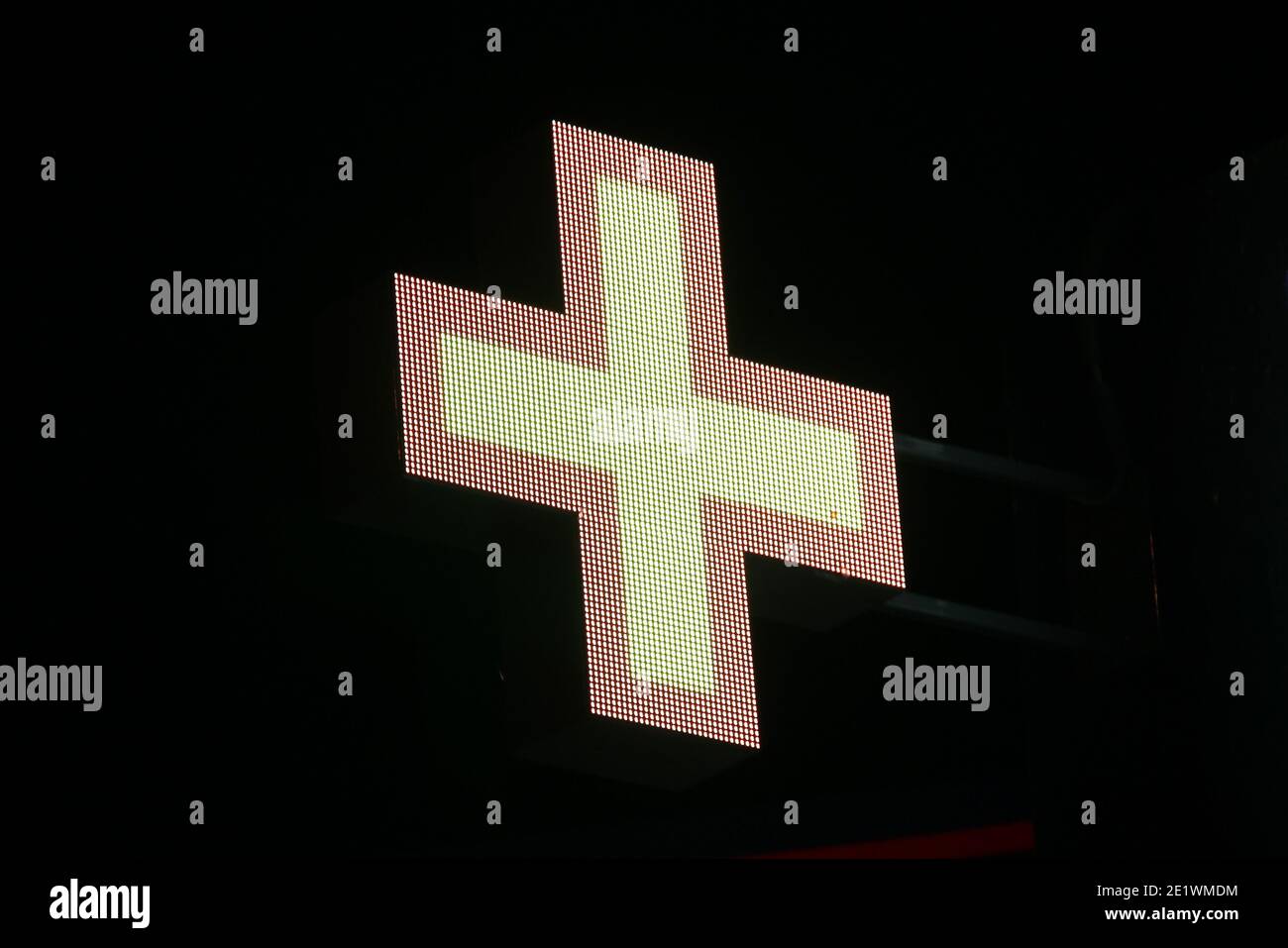 Glowing pixel cross of LED lamps on black background. Orange cross with ...