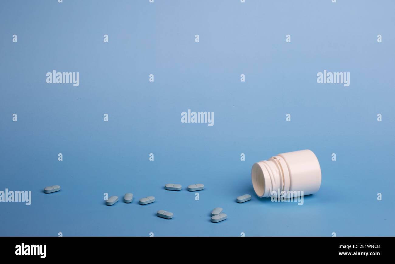 Medicine blue pills and white bottle Stock Photo - Alamy