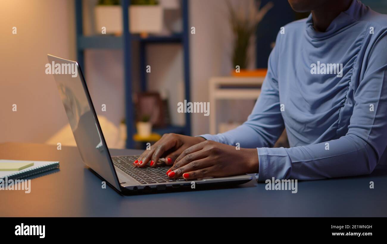 Busy black employee typing on computer sitting on chair in modern ...