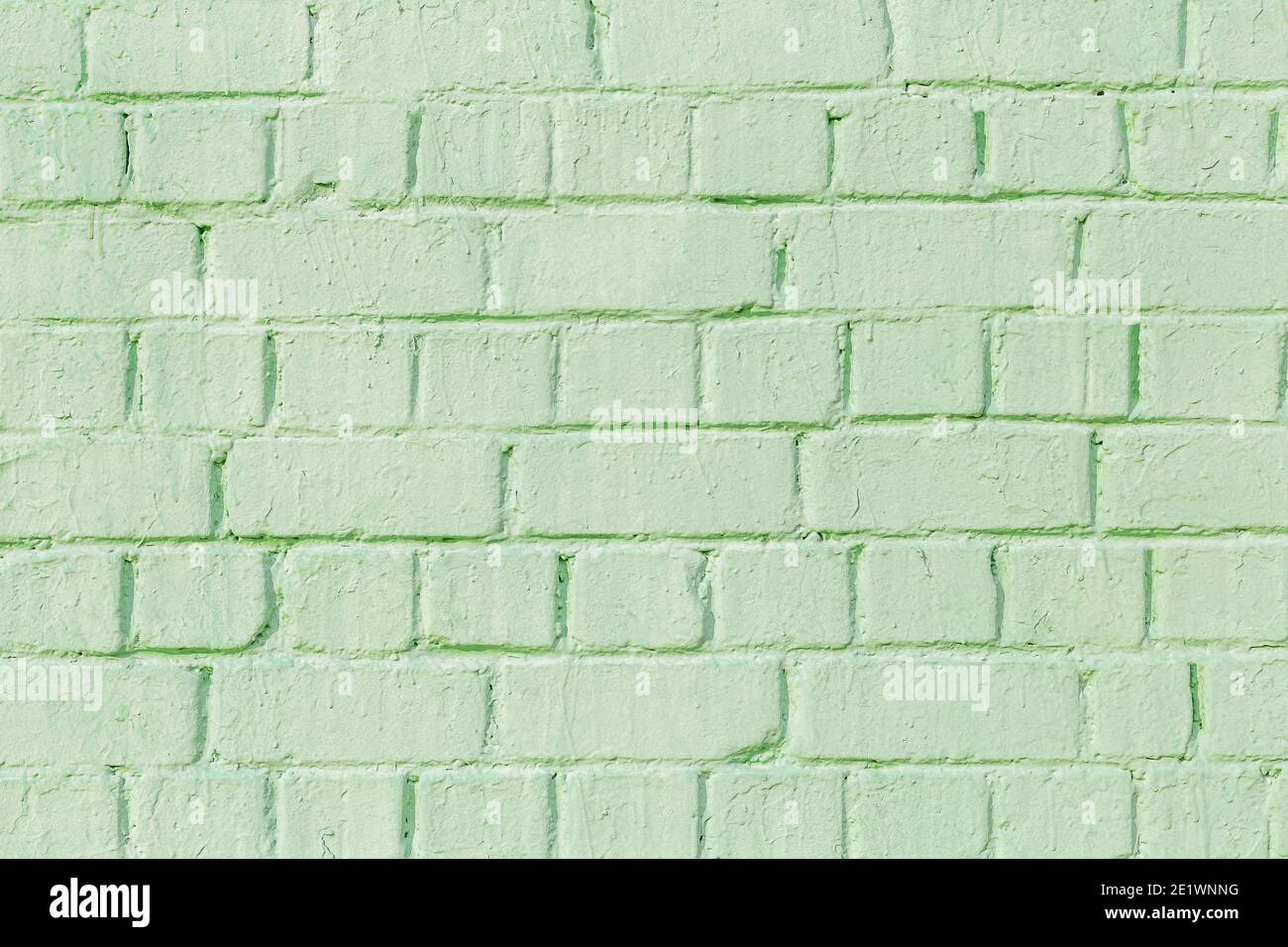 Background with brick, uneven texture wall. Brickwork is painted green ...