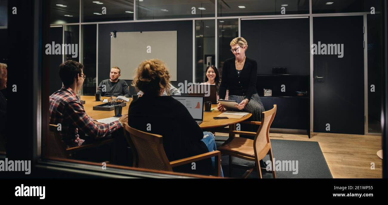 Team of business people sitting together in discussion around ...