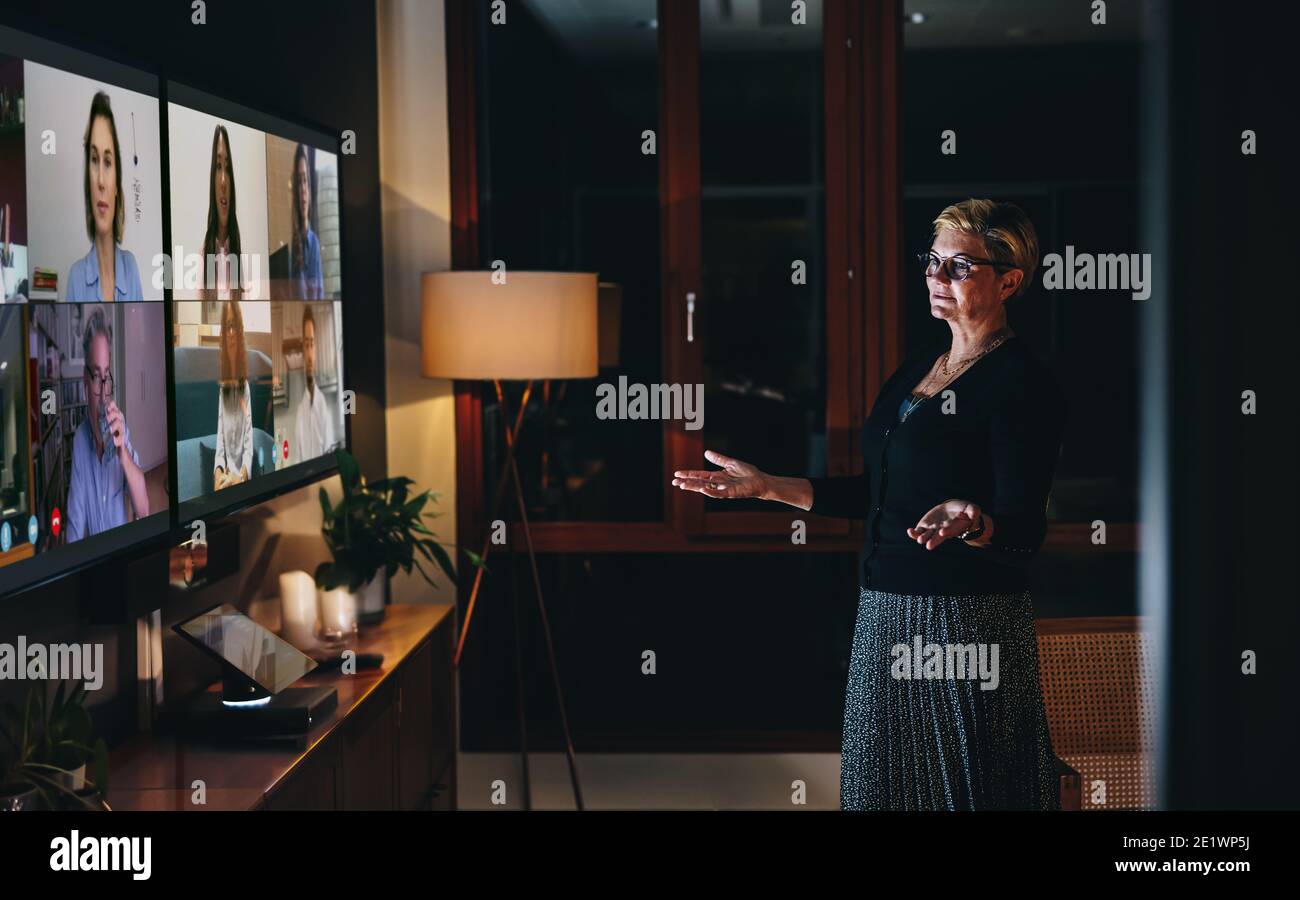 businesswoman leading a video conference call late night. Multi-ethnic ...
