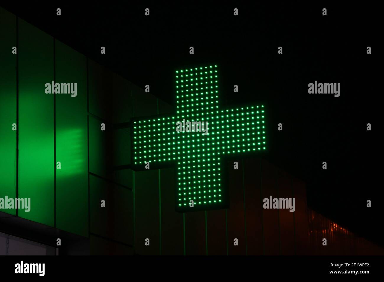 Glowing pixel cross of LED lamps on black background. Green cross ...