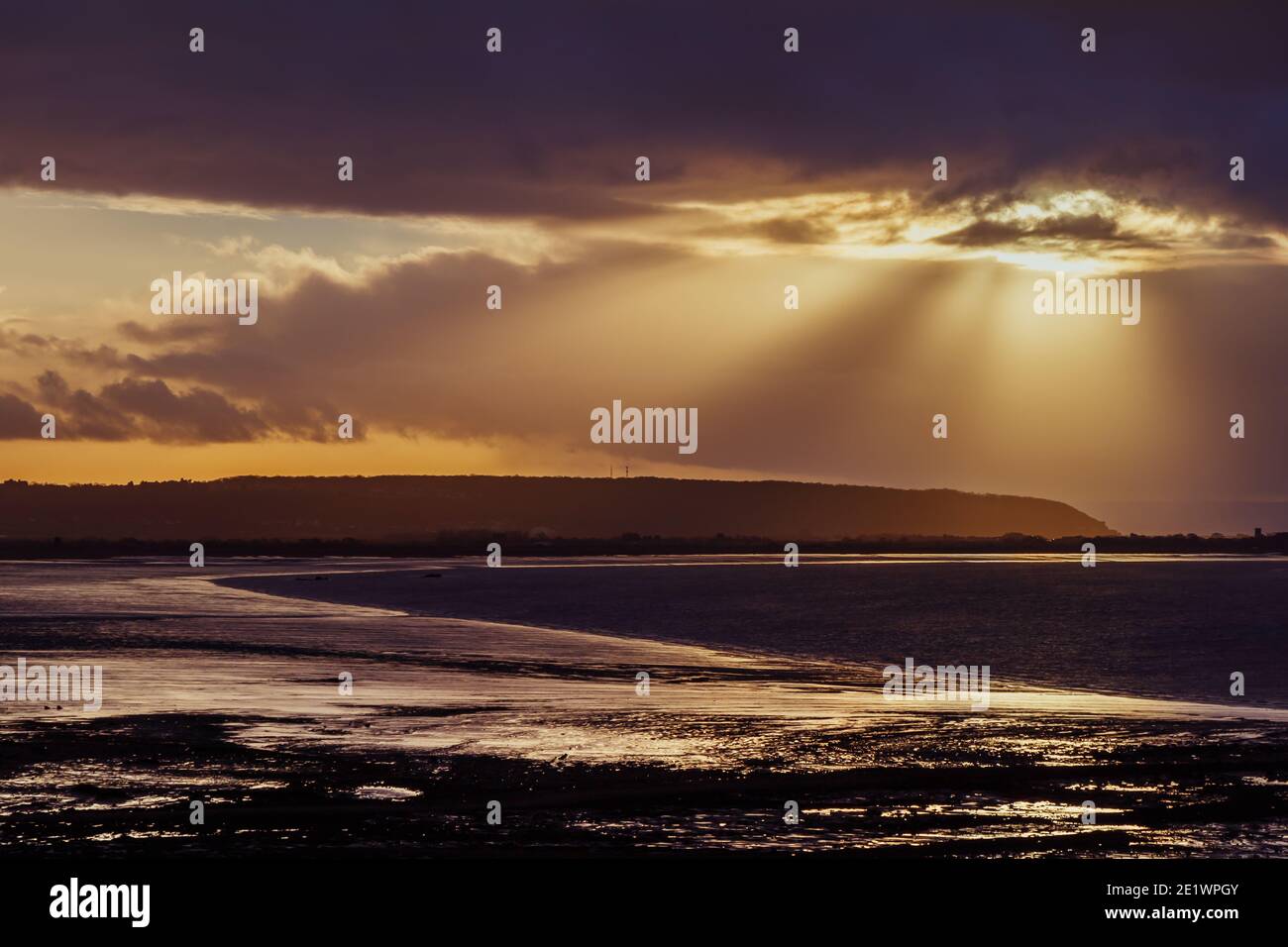 Crepuscular rays breaking through the dark cloud cover Stock Photo - Alamy