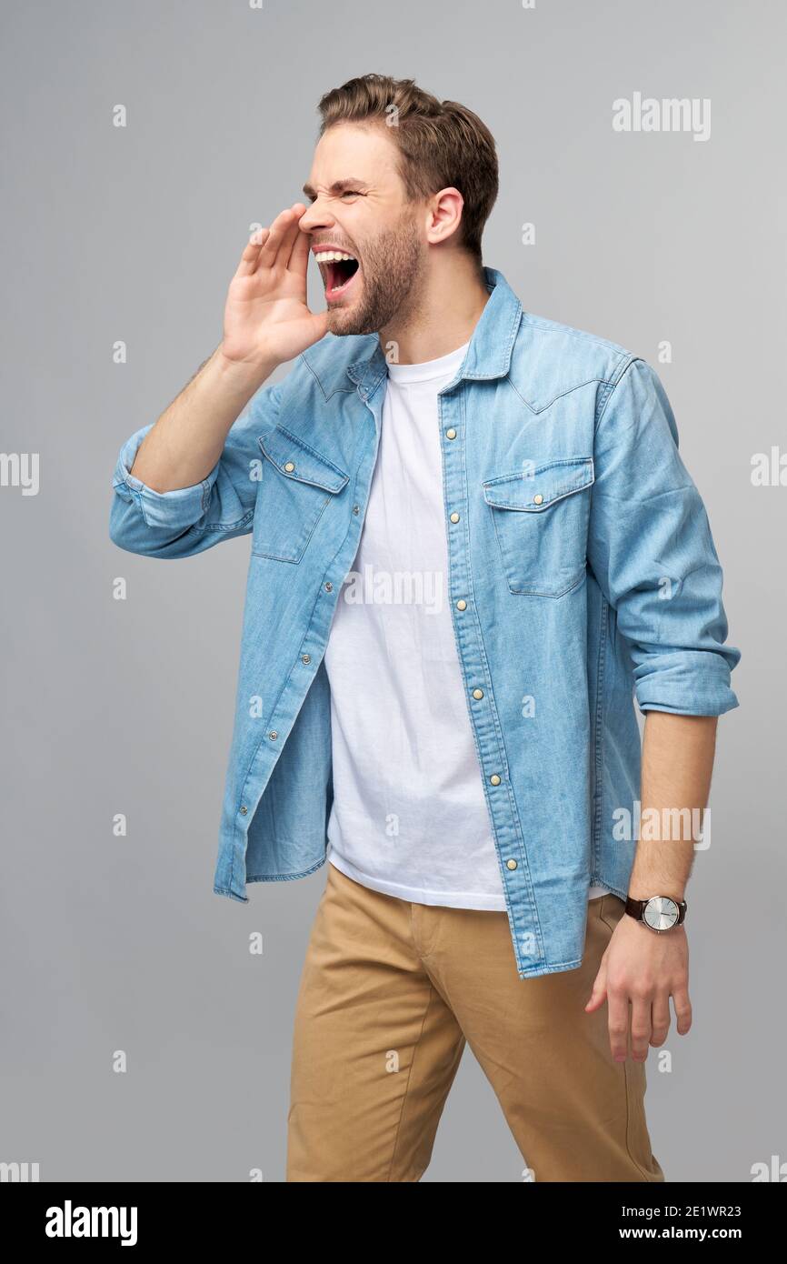 Screaming emotional angry man screaming standing over grey studio ...