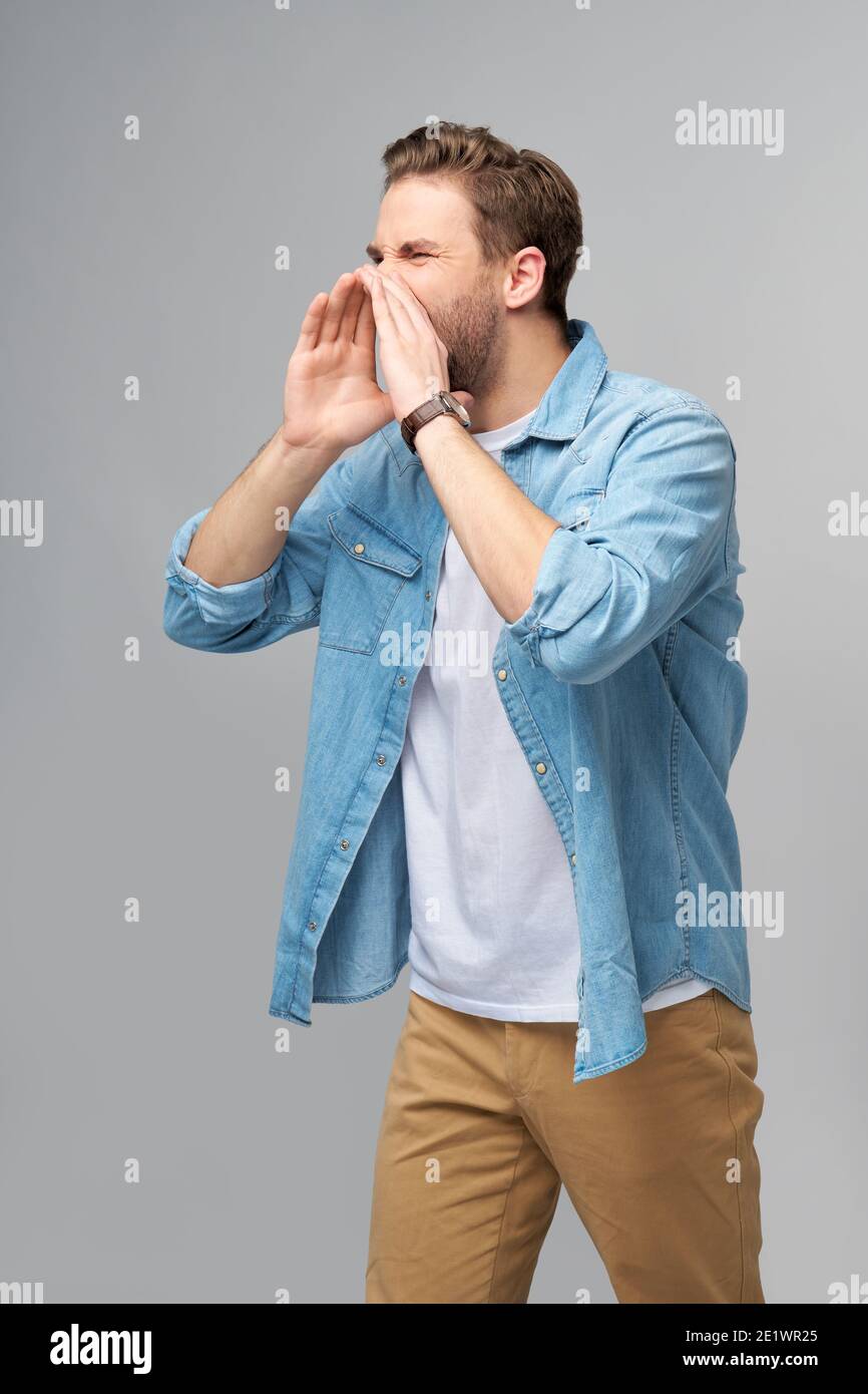 Screaming emotional angry man screaming standing over grey studio ...